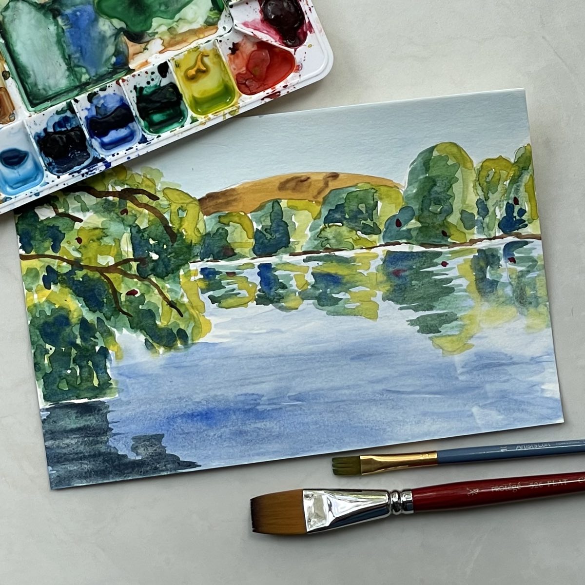 Paint an easy watercolor lake scene step-by-step | Fun Family Crafts